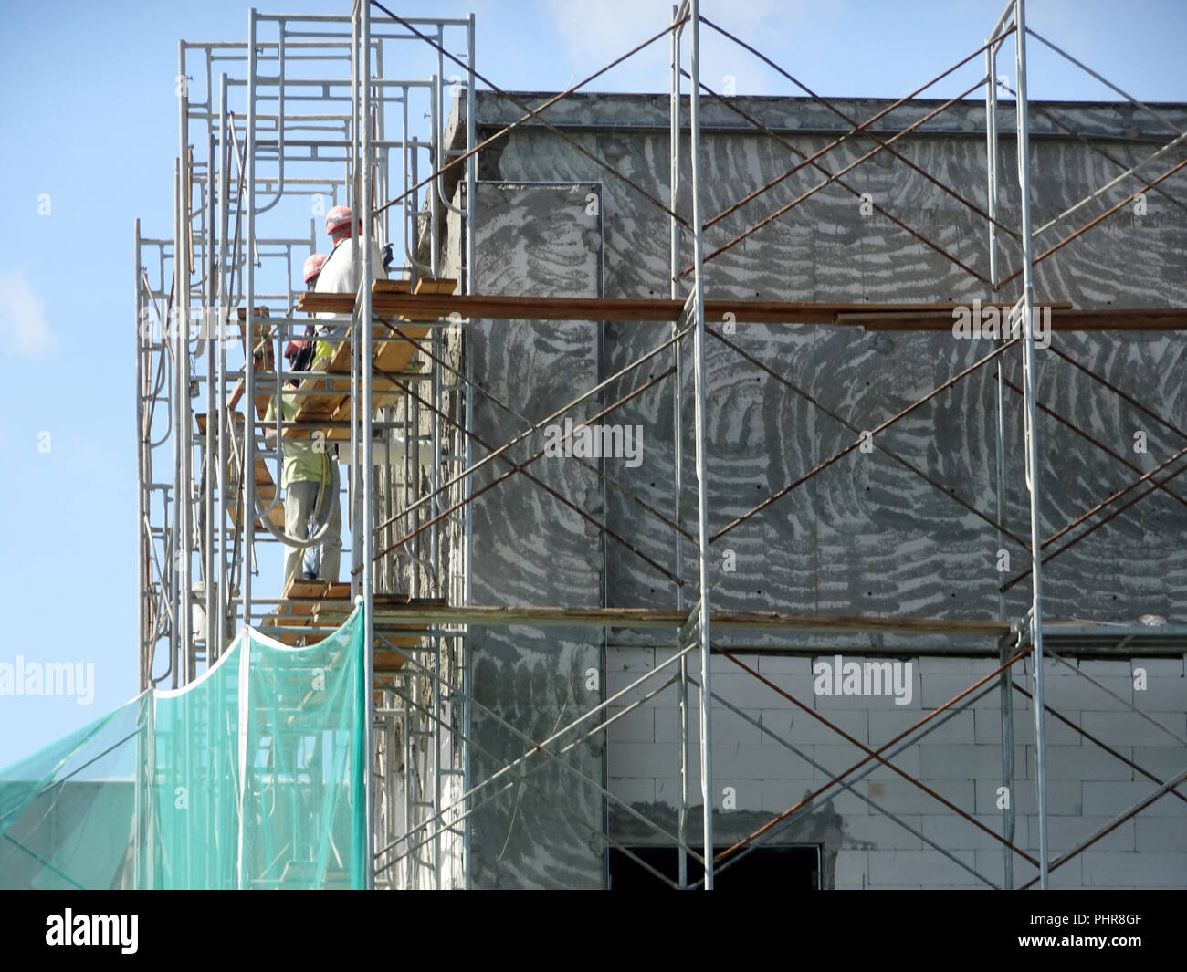 Construction workers plastering wall using cement plaster at the ...