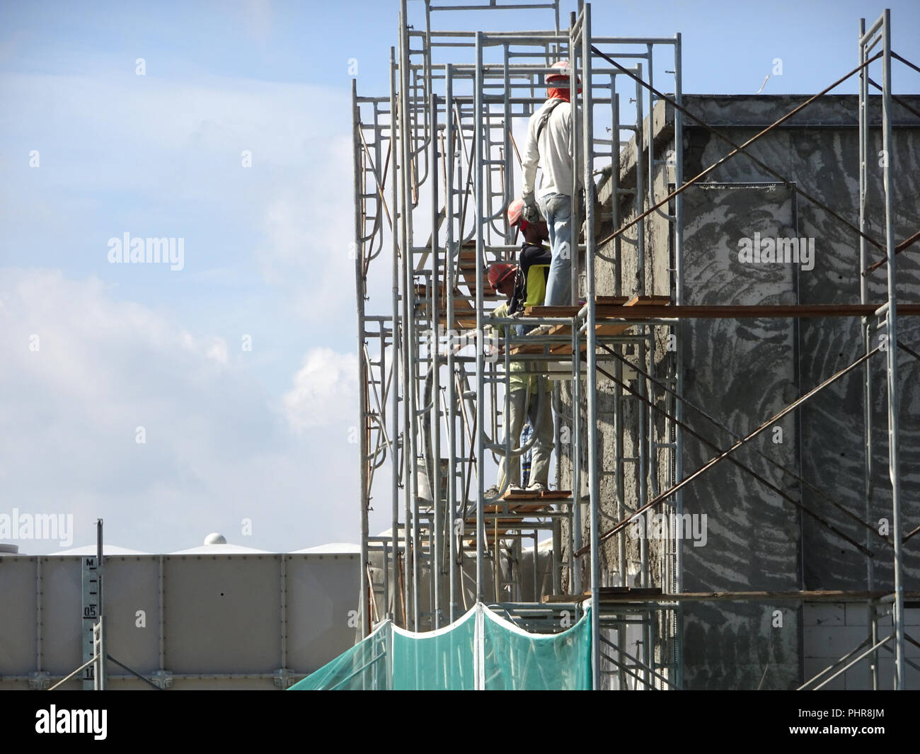 Construction workers plastering wall using cement plaster at the ...