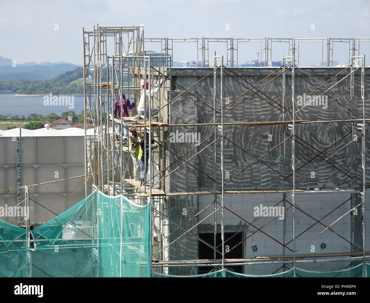 Construction workers plastering wall using cement plaster at the ...