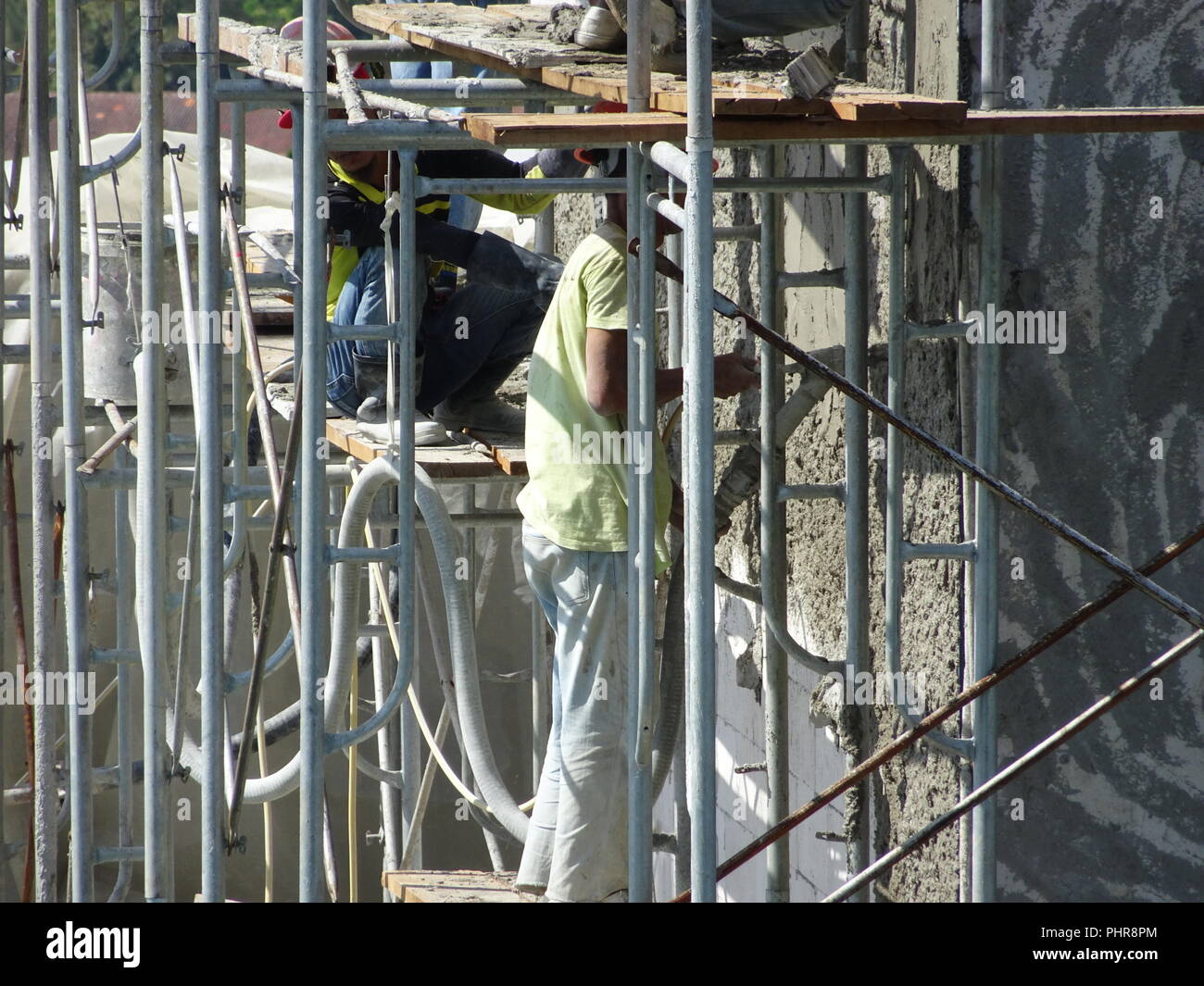 Construction workers plastering wall using cement plaster at the ...