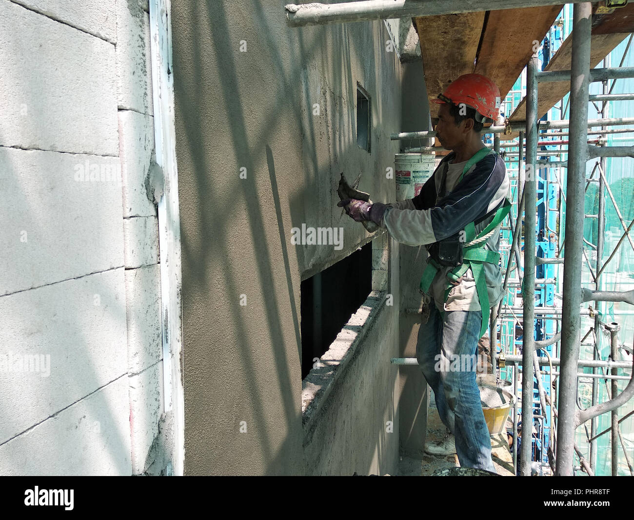 Construction workers plastering wall using cement plaster at the ...
