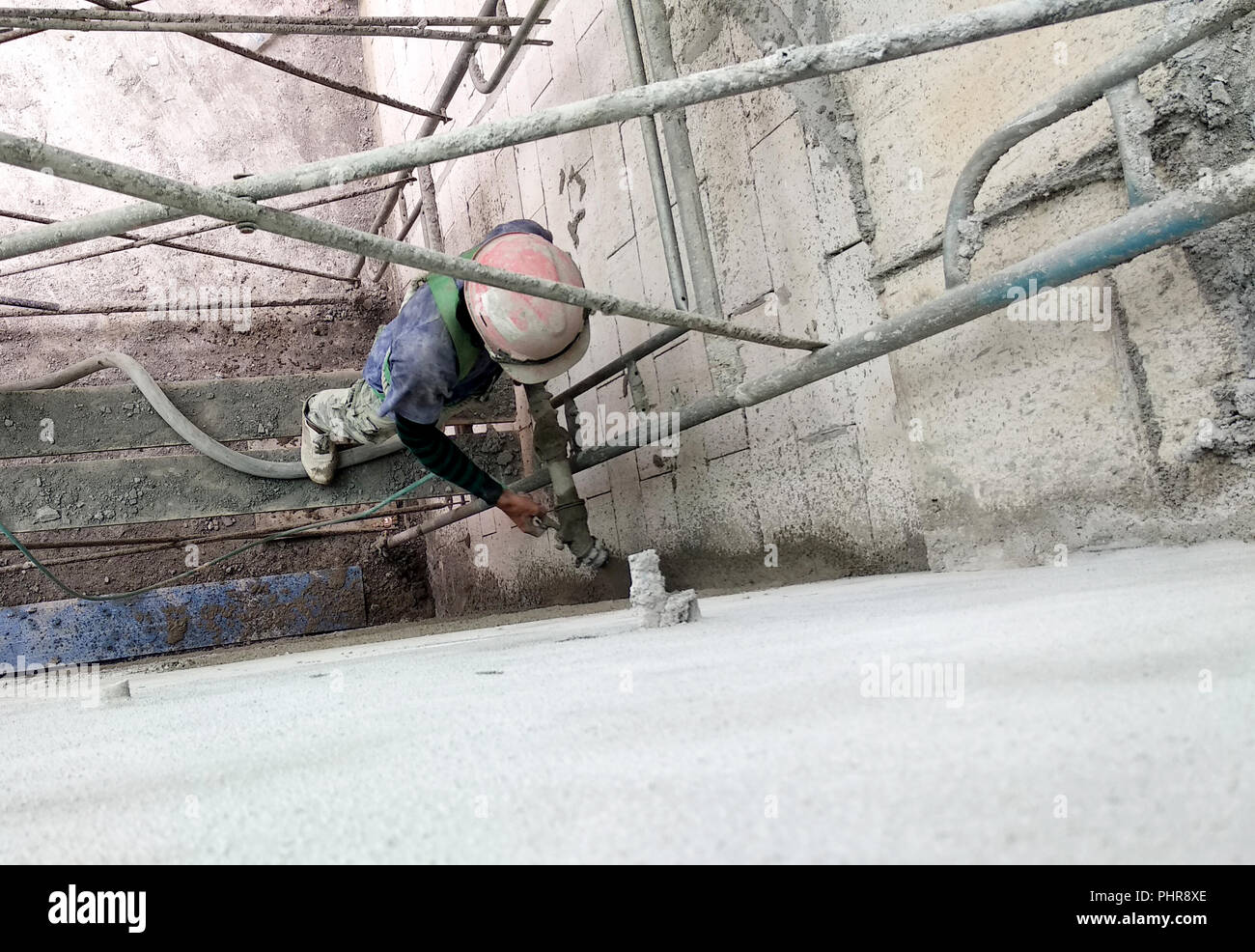 Construction workers plastering wall using cement plaster at the ...