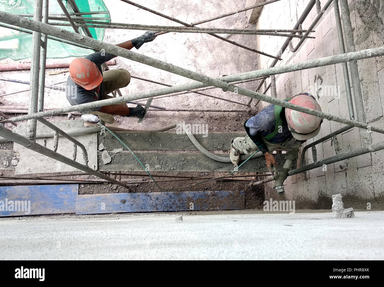 Construction workers plastering wall using cement plaster at the ...