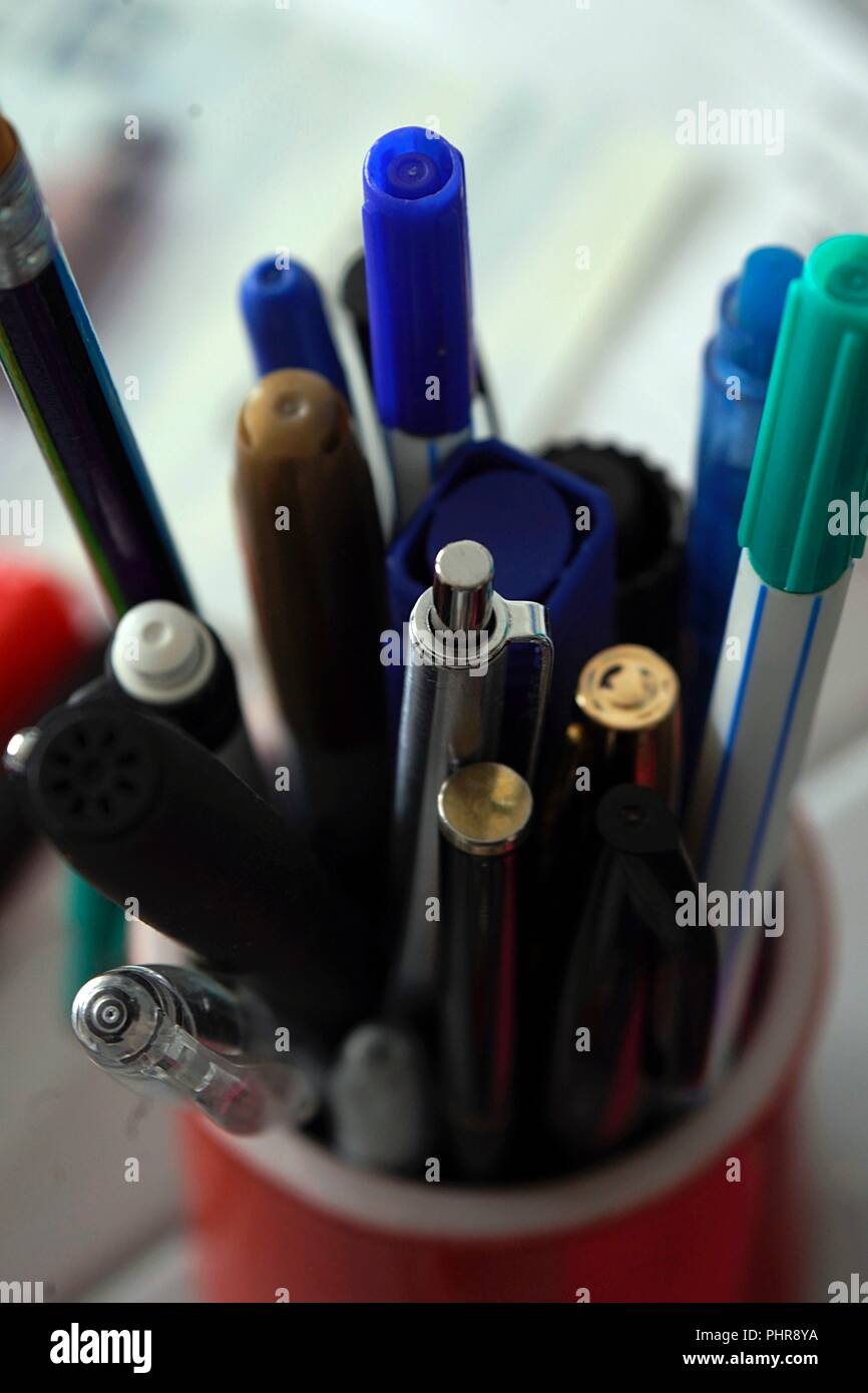 Pen Pot containing pens and markers on an office desk Stock Photo - Alamy