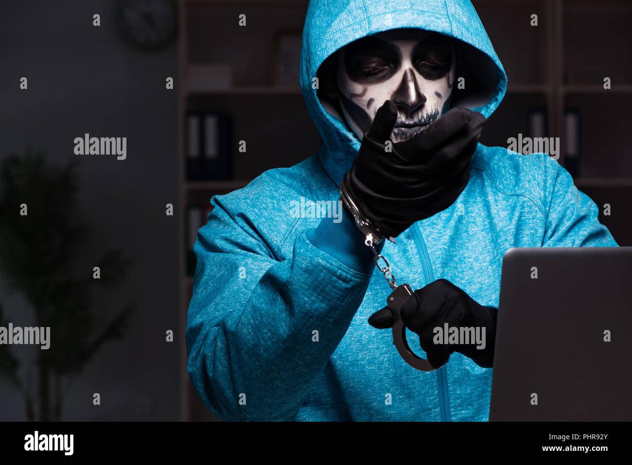 Scary hacker hacking security firewall late in office Stock Photo - Alamy