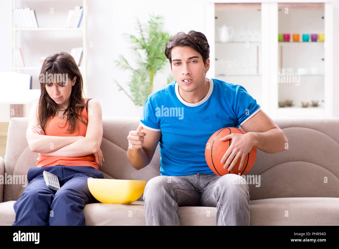 Man watching basketball with his wife Stock Photo - Alamy