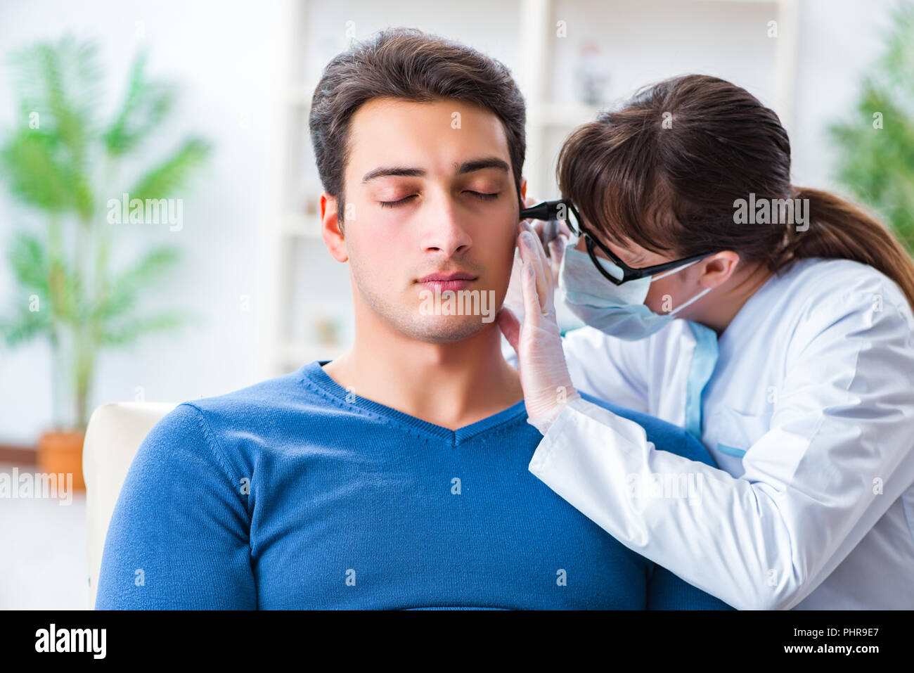 Doctor checking patients ear during medical examination Stock Photo - Alamy