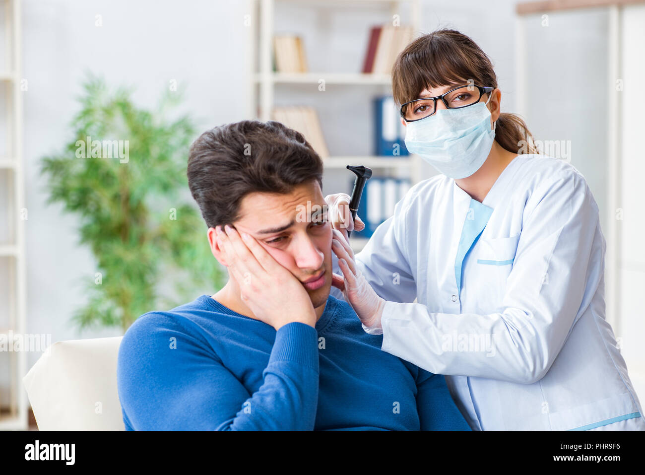 Doctor checking patients ear during medical examination Stock Photo - Alamy