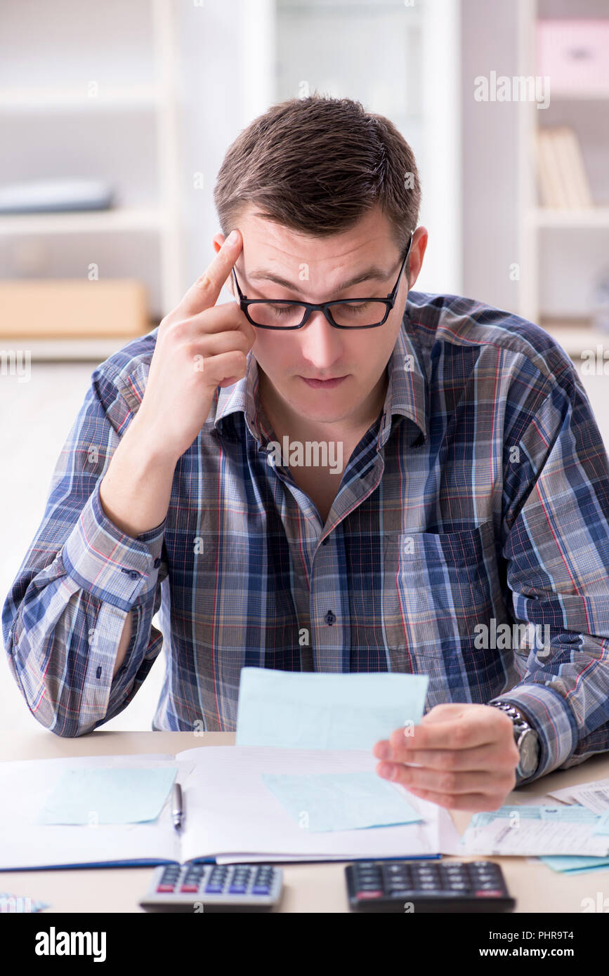 Young man frustrated at his house and tax bills Stock Photo - Alamy
