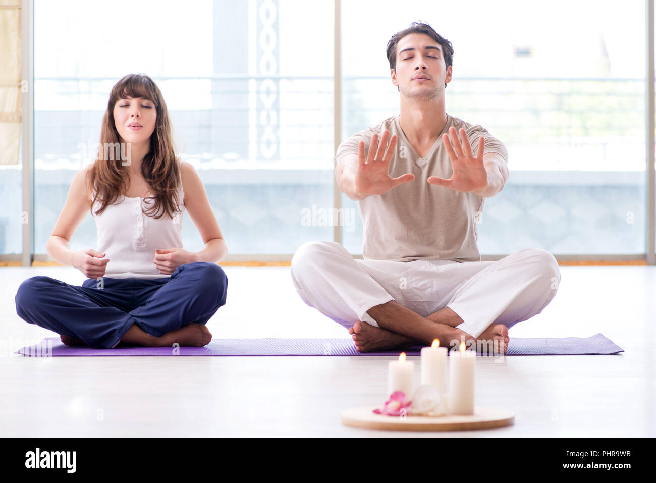 Personal coach helping during yoga session Stock Photo - Alamy