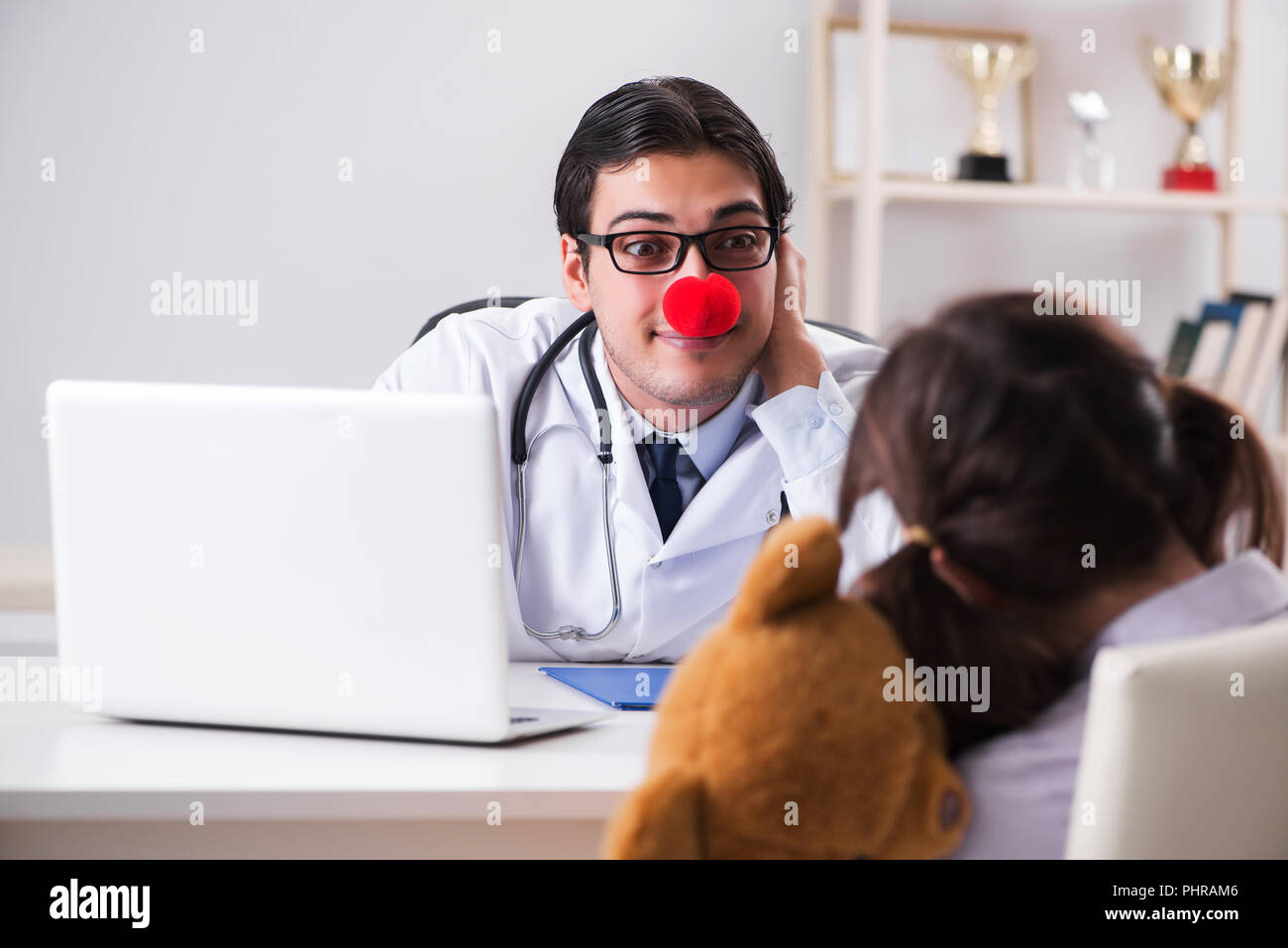 Funny pediatrician with little girl at regular check-up Stock Photo - Alamy