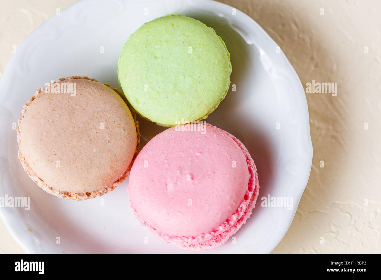 Colourful macaroons on the plates Stock Photo - Alamy