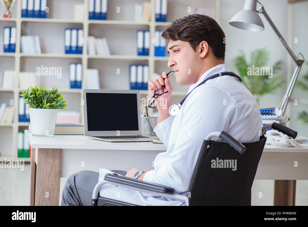 Disabled doctor on wheelchair working in hospital Stock Photo - Alamy