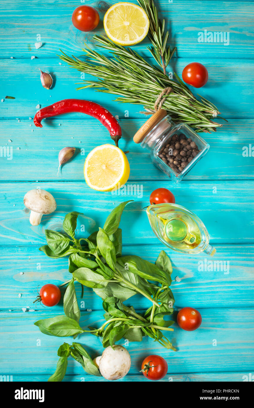 Food cooking background on blue wood table. Rosemary, basil, tomatoes ...