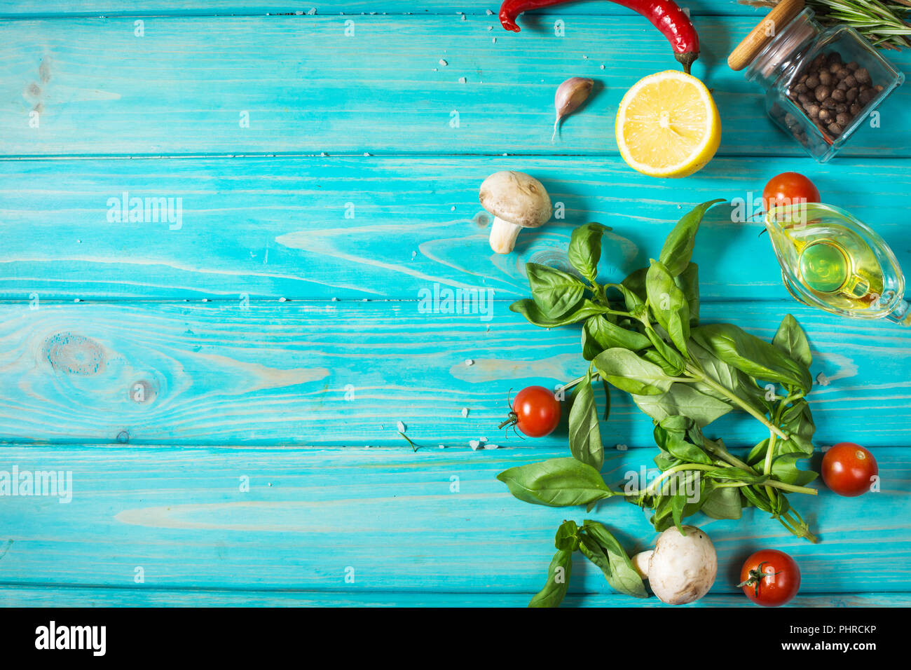 Food cooking background on blue wood table. Rosemary, basil, tomatoes ...