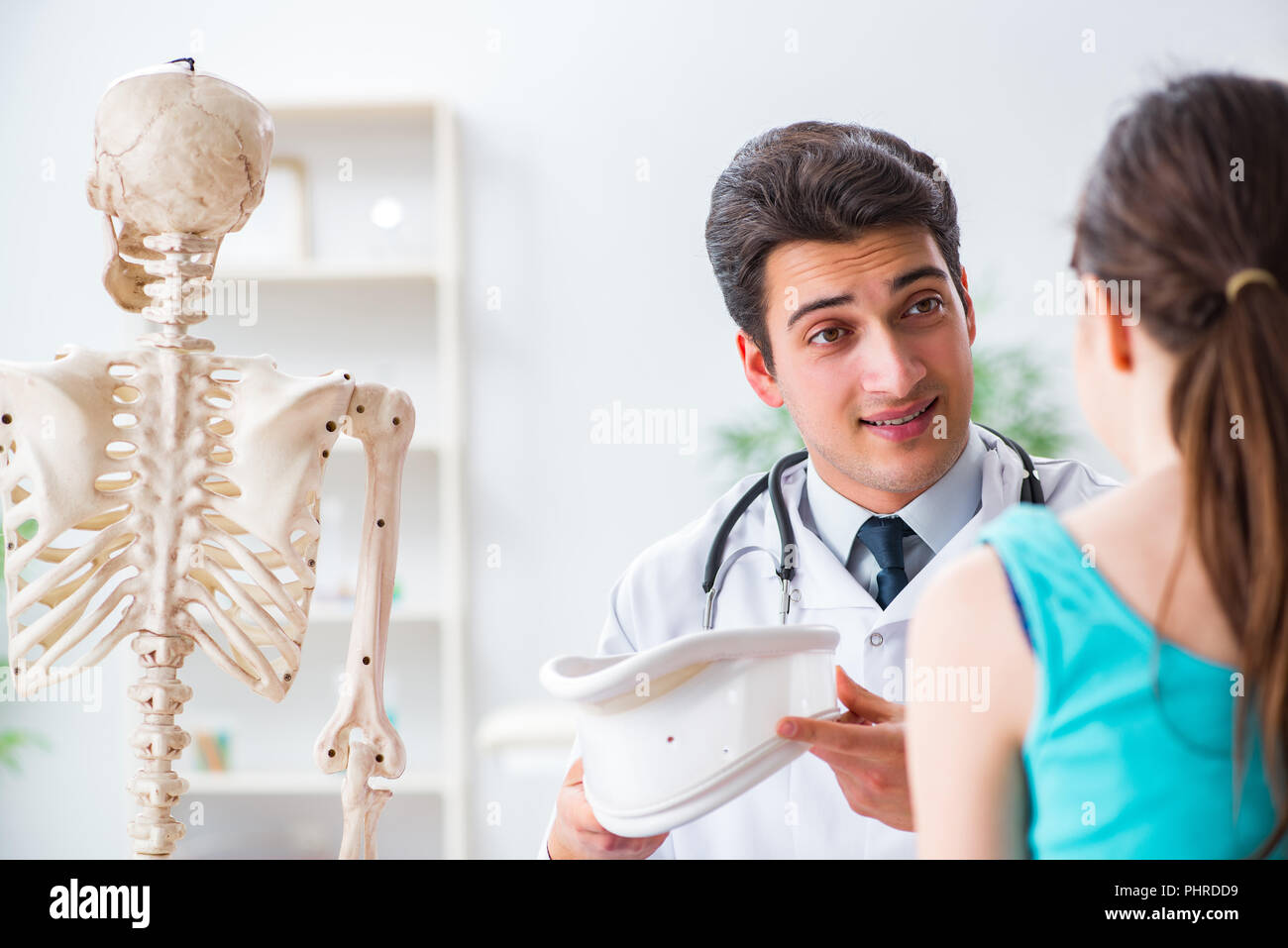 Doctor showing type of injury on skeleton to patient Stock Photo - Alamy