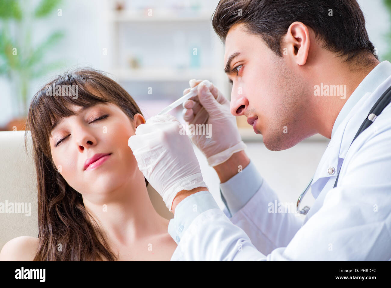 Doctor checking patients ear during medical examination Stock Photo - Alamy