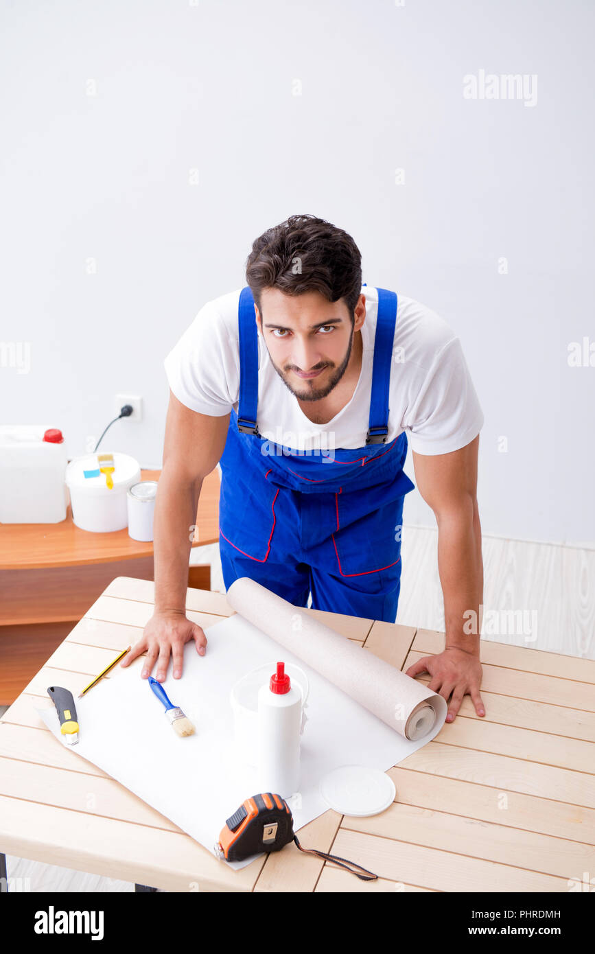 Worker working on wallpaper during refurbishment Stock Photo - Alamy