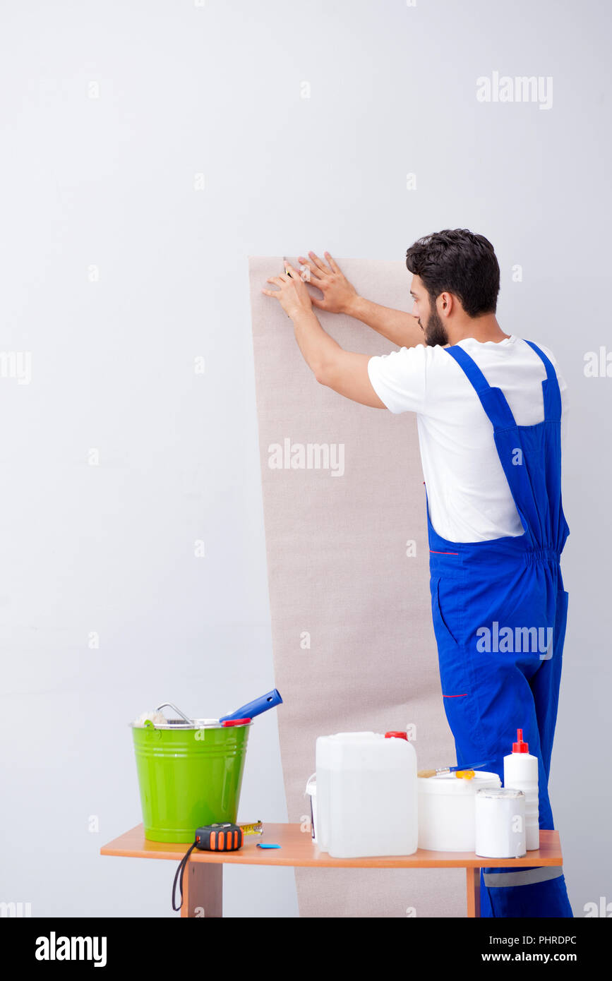 Worker working on wallpaper during refurbishment Stock Photo - Alamy