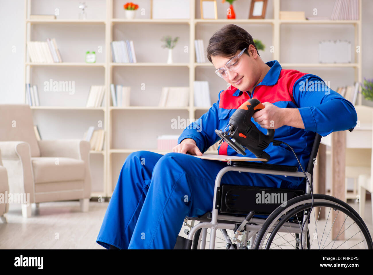 Disabled man working with handsaw at home Stock Photo - Alamy