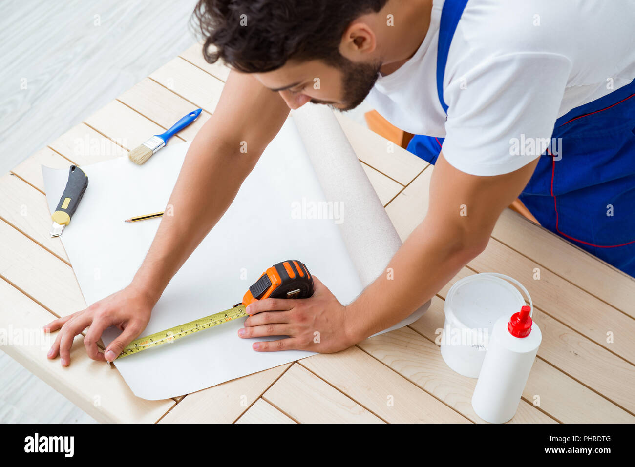 Worker working on wallpaper during refurbishment Stock Photo - Alamy