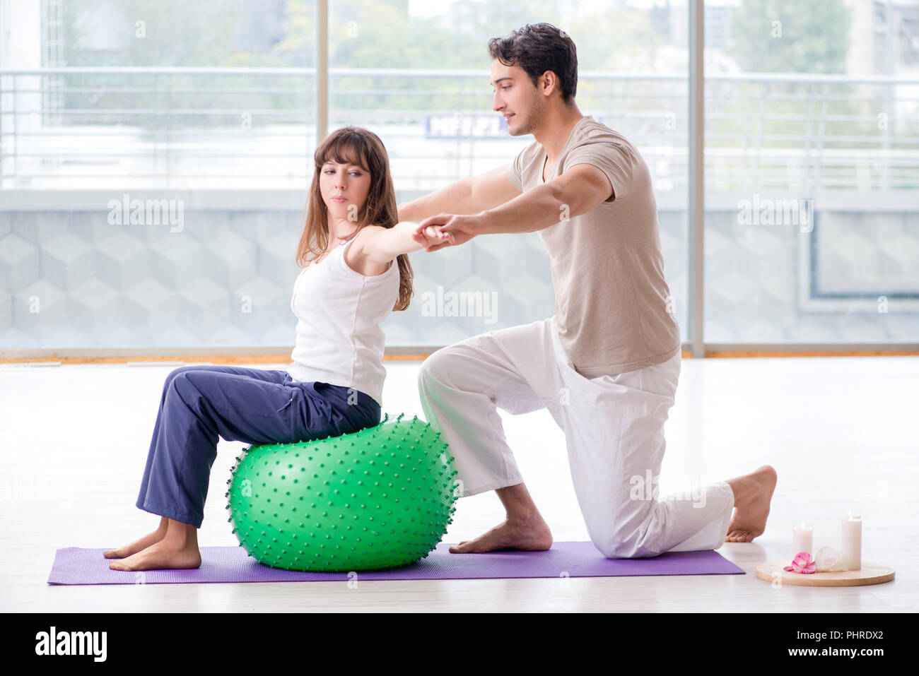 Personal coach helping woman in gym with stability ball Stock Photo - Alamy