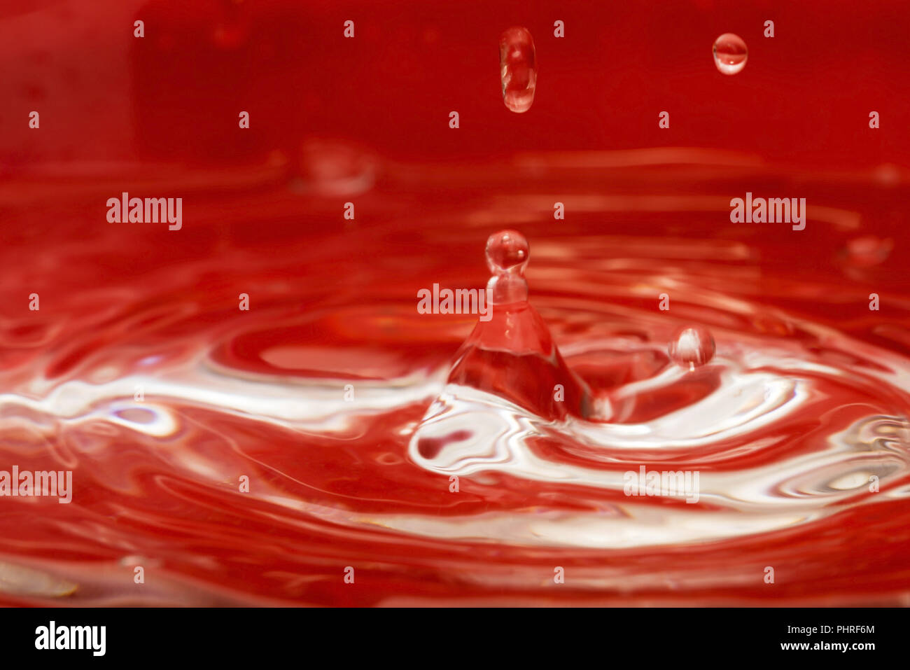 Water drop on a red background Stock Photo - Alamy
