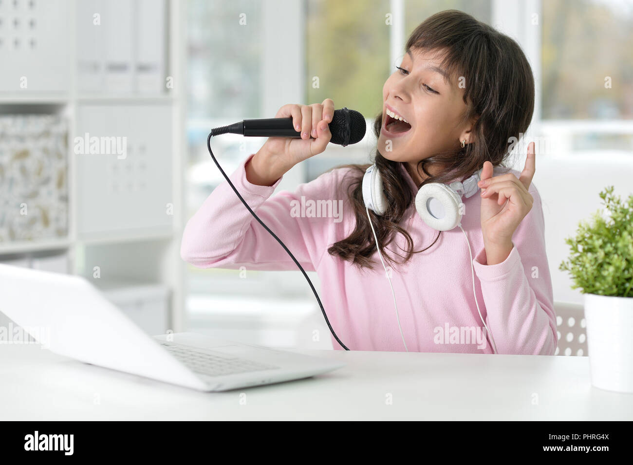 Portrait of a cute girl singing songs Stock Photo - Alamy