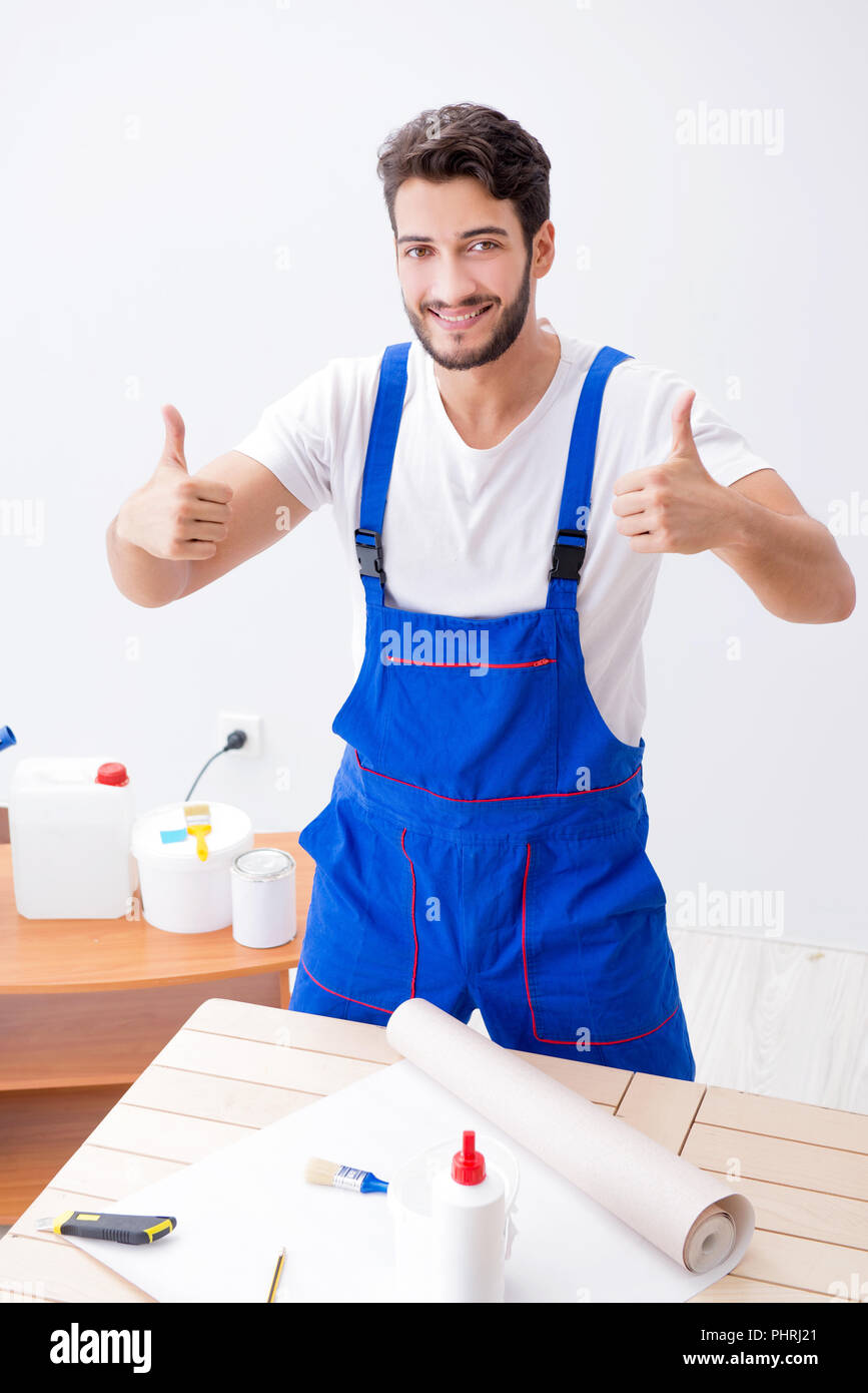 Worker working on wallpaper during refurbishment Stock Photo - Alamy
