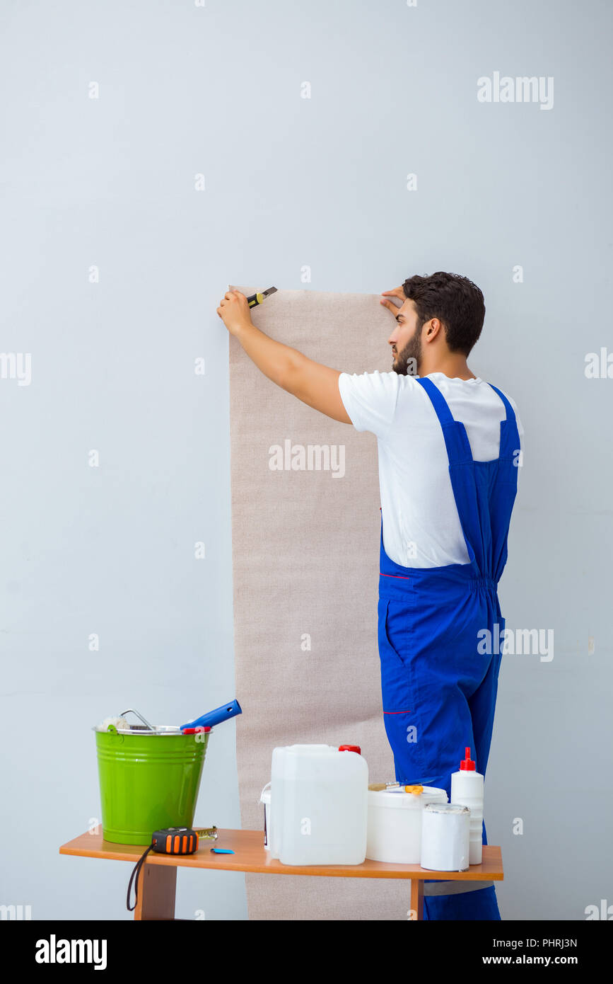 Worker working on wallpaper during refurbishment Stock Photo - Alamy