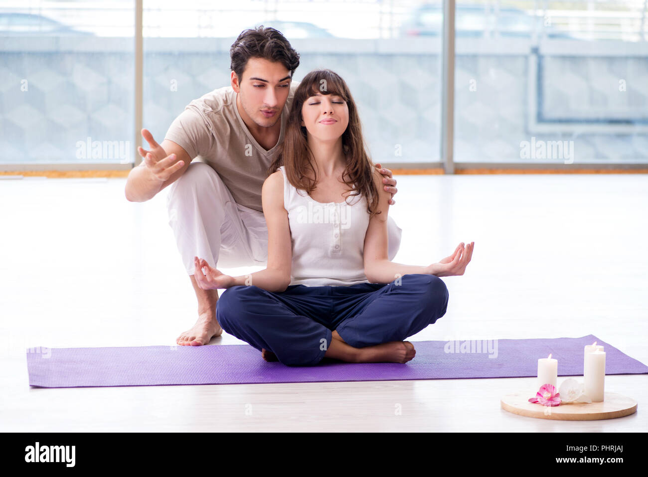 Personal coach helping during yoga session Stock Photo - Alamy