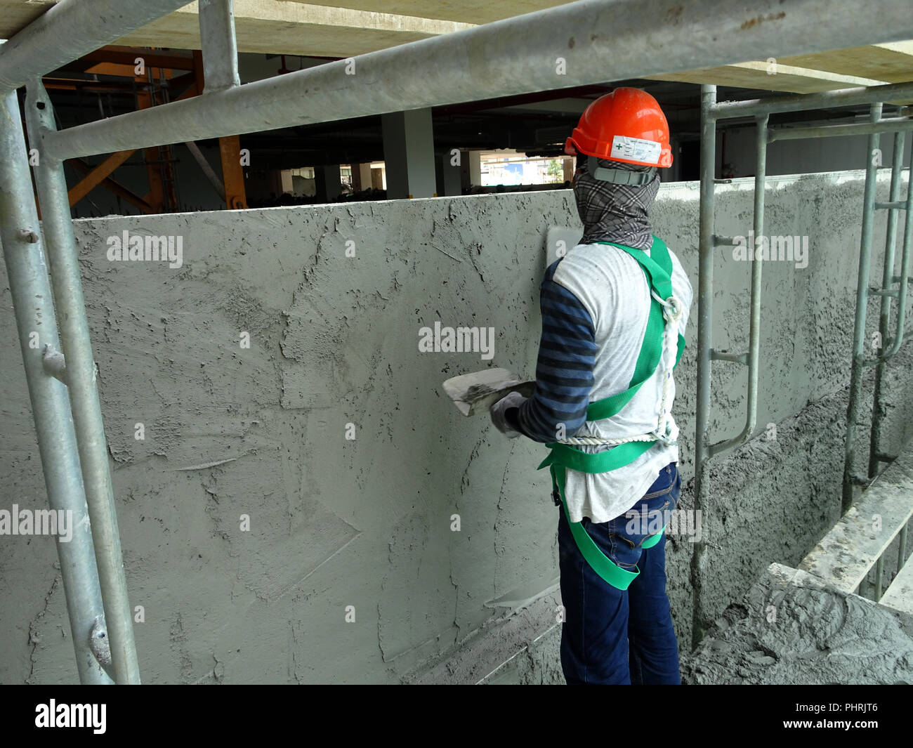 Construction workers plastering wall using cement plaster at the ...