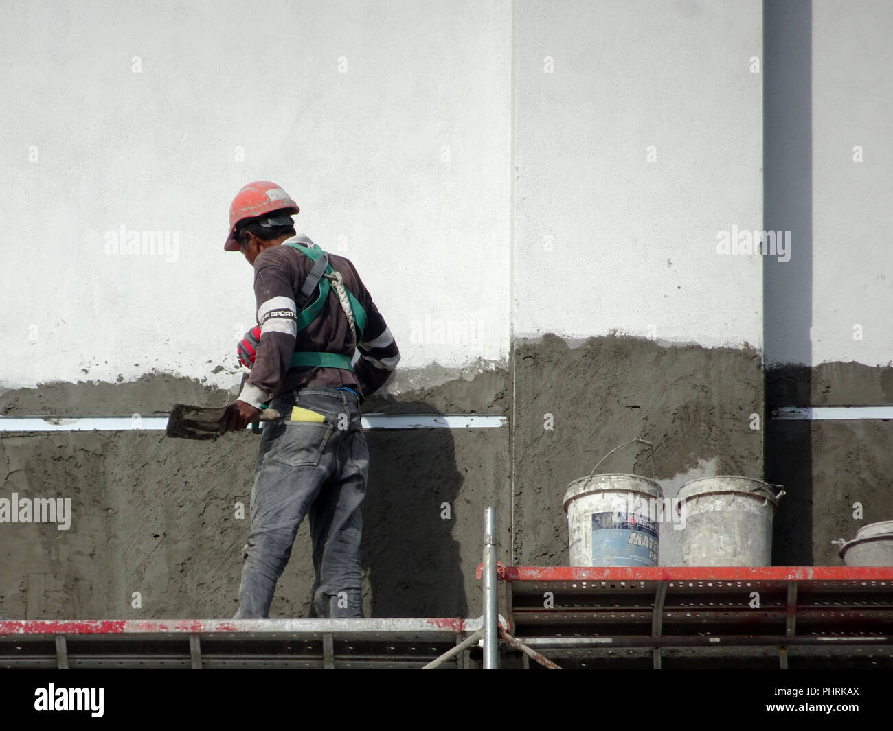 Construction workers plastering wall using cement plaster at the ...