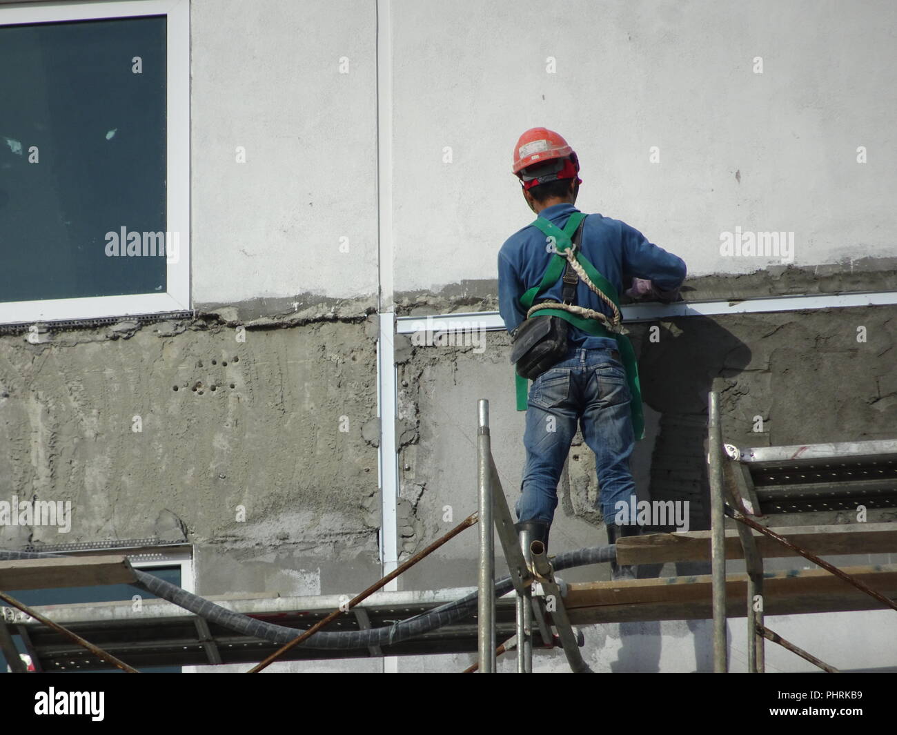 Construction workers plastering wall using cement plaster at the ...