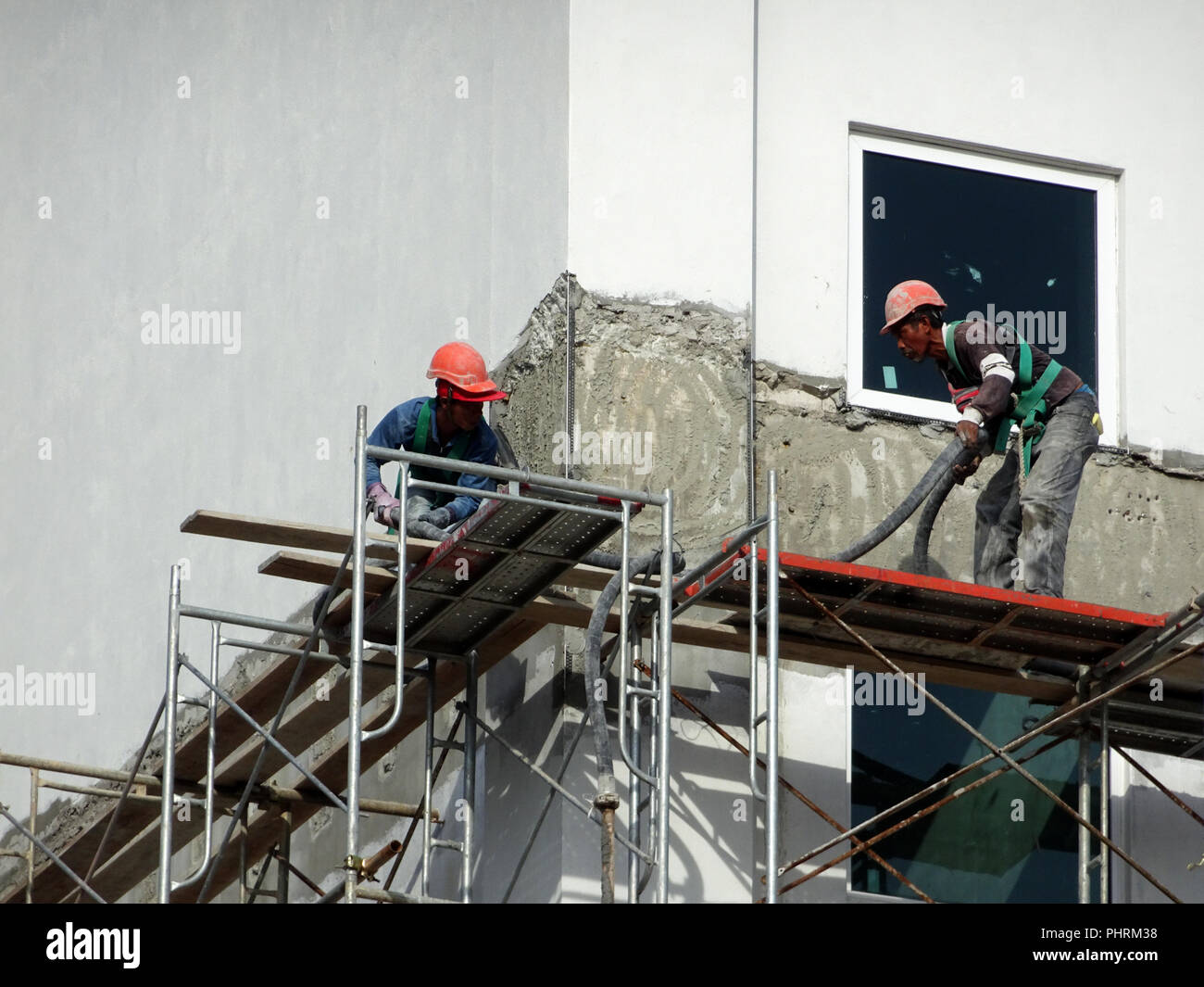Construction workers plastering wall using cement plaster at the ...