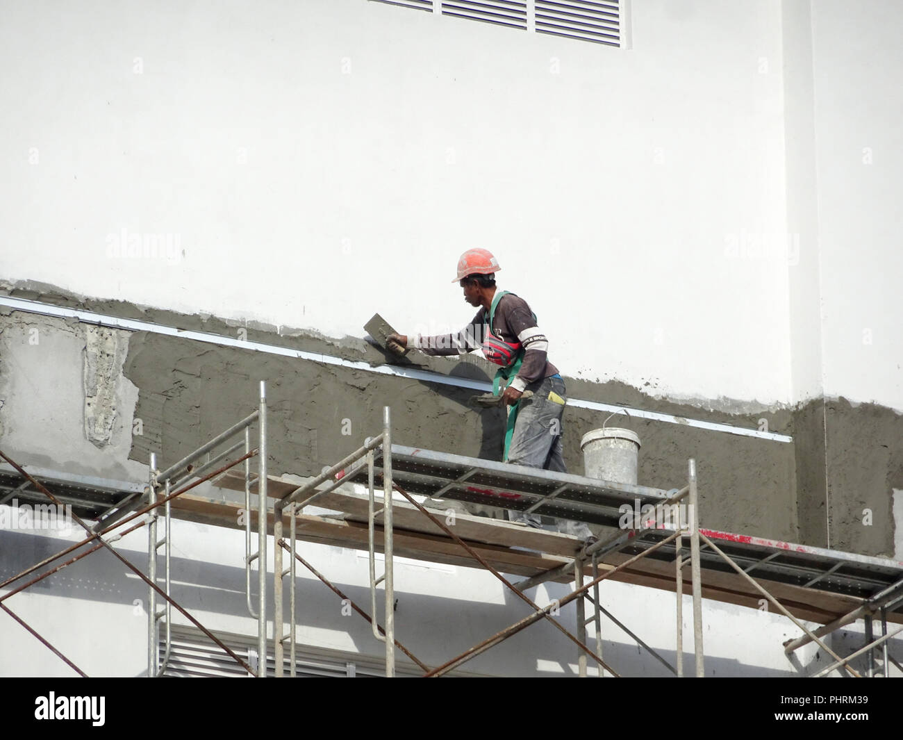 Construction workers plastering wall using cement plaster at the ...
