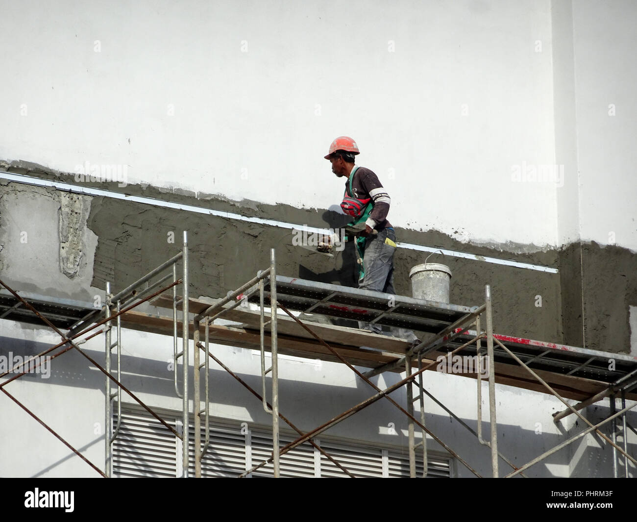 Construction workers plastering wall using cement plaster at the ...