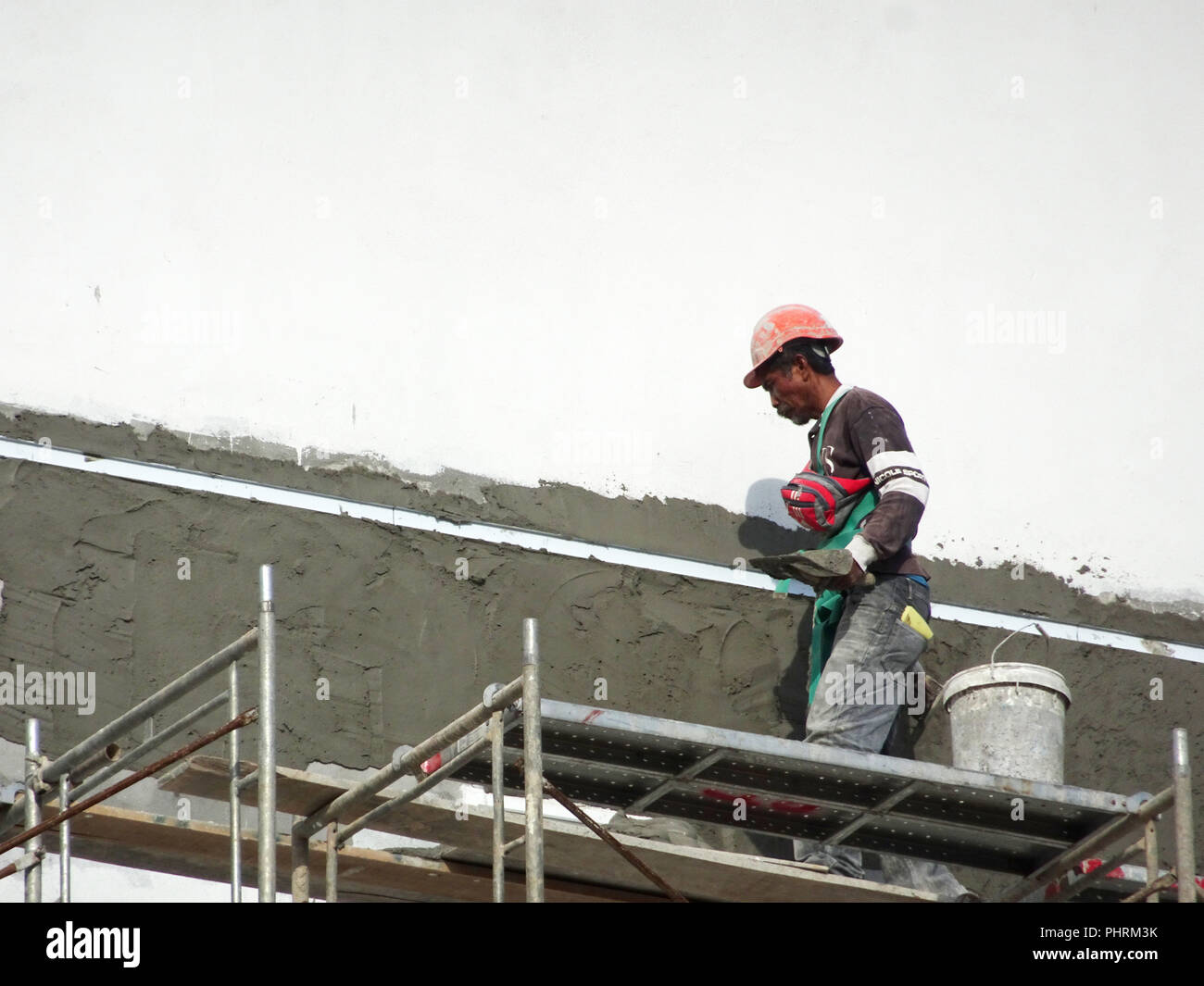 Construction workers plastering wall using cement plaster at the ...