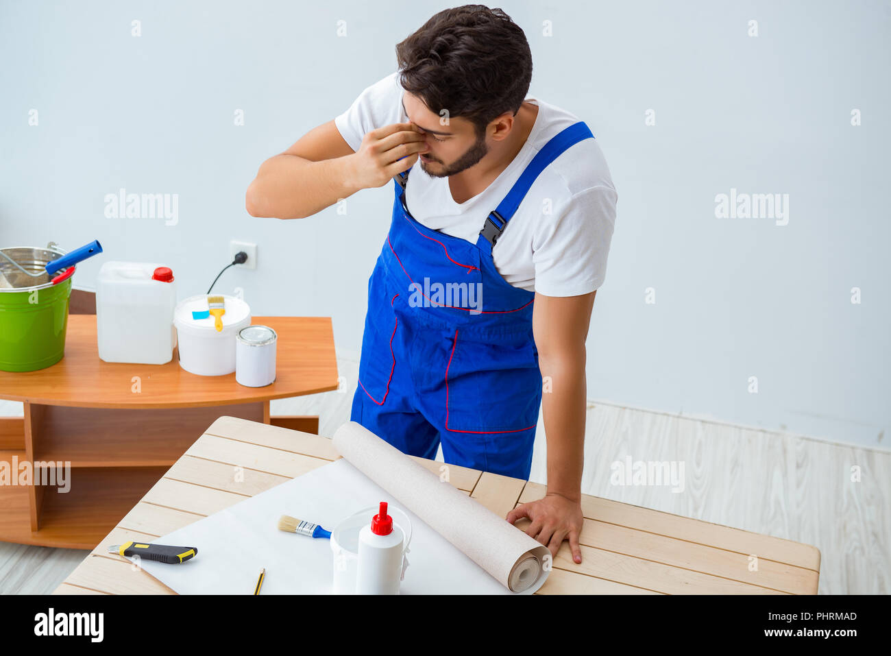 Worker working on wallpaper during refurbishment Stock Photo - Alamy