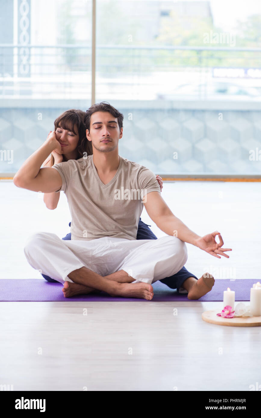 Personal coach helping during yoga session Stock Photo - Alamy
