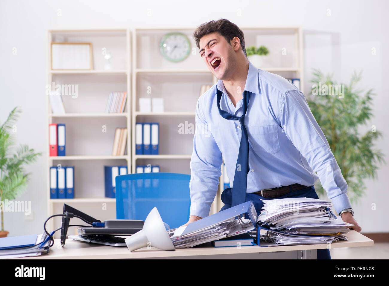 Angry businessman frustrated with too much work Stock Photo - Alamy