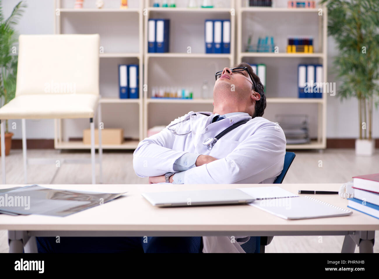 Young doctor sitting in the office Stock Photo - Alamy