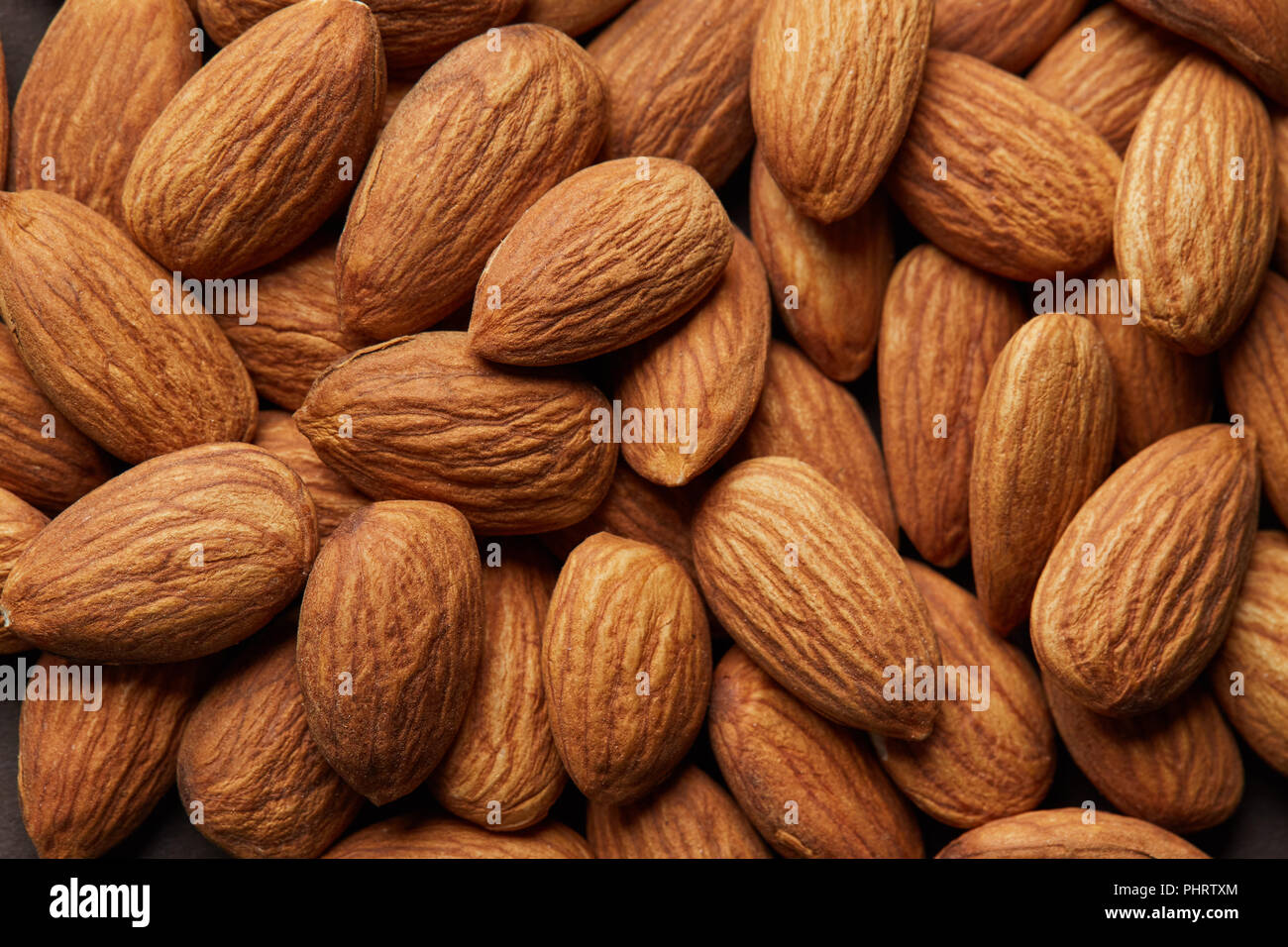 Pile of almonds close-up as background Stock Photo - Alamy