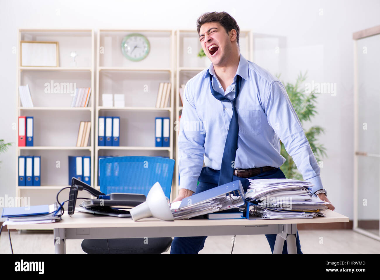 Angry businessman frustrated with too much work Stock Photo - Alamy