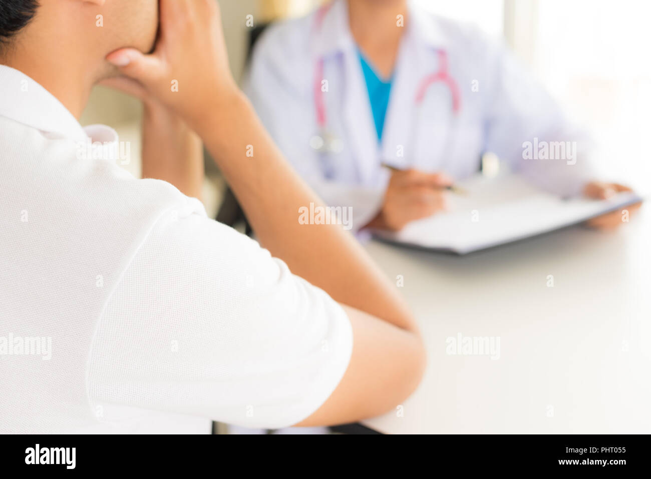 Female doctor have discussion with patient man covering face with hand ...