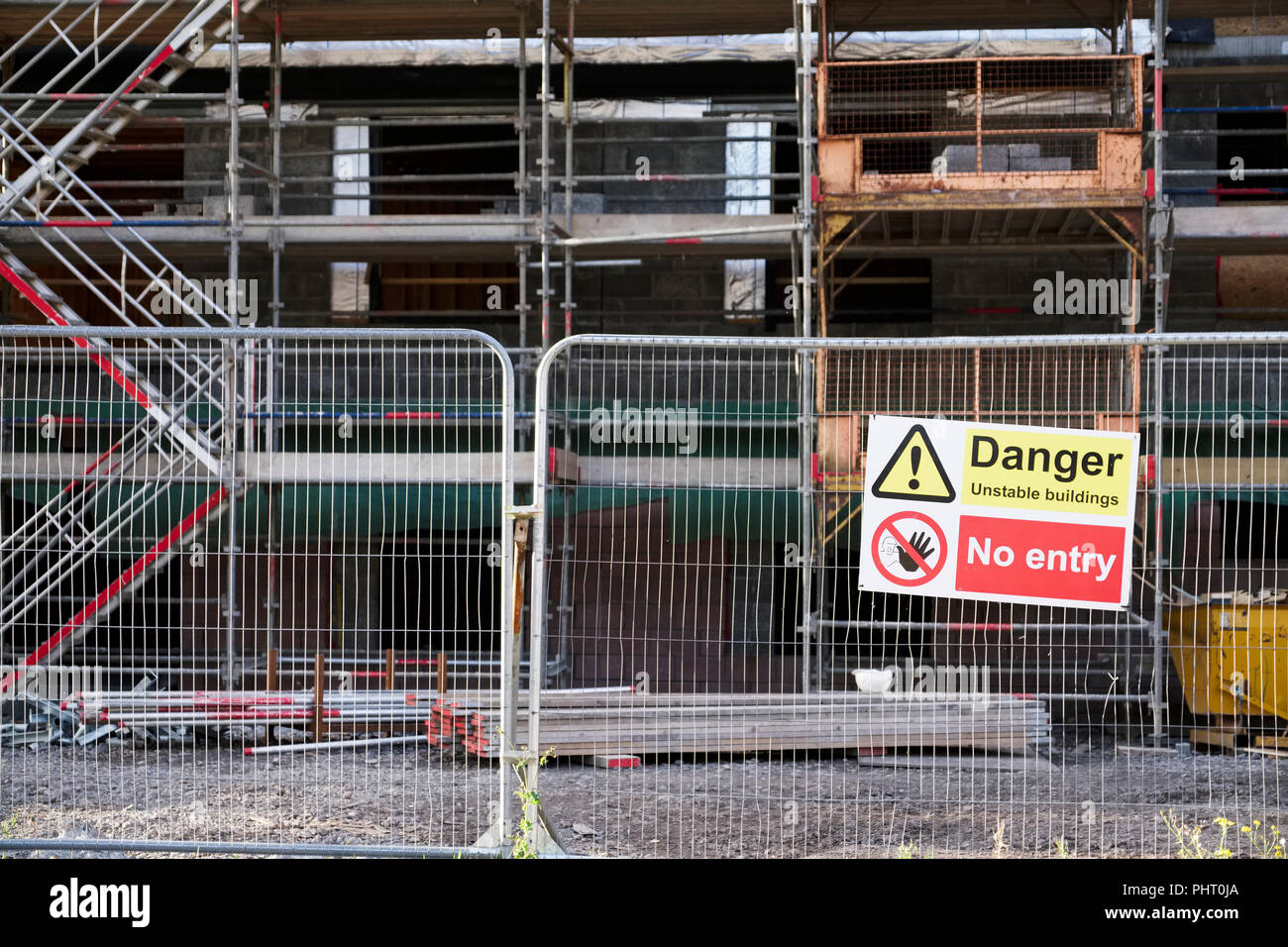 Unstable building keep out dangerous sign on fence at building ...