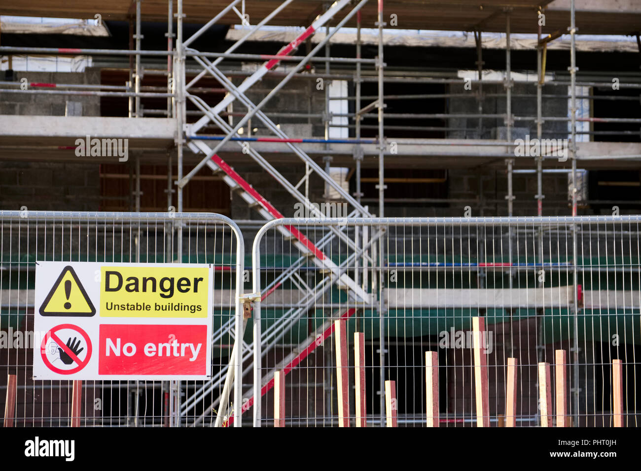 Unstable building keep out dangerous sign on fence at building ...