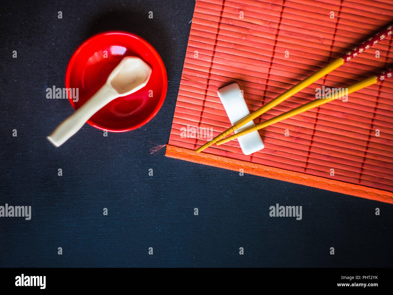 Table setting in red color for asian cuisine dinner with chopsticks ...