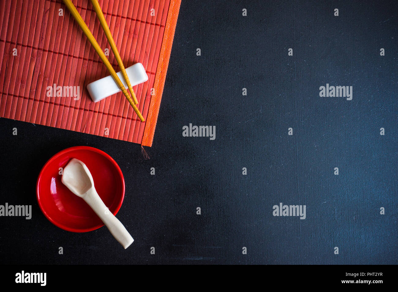 Table setting in red color for asian cuisine dinner with chopsticks ...