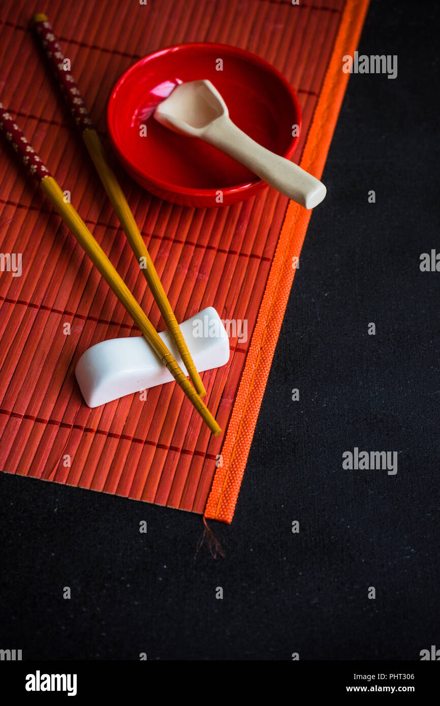 Table setting in red color for asian cuisine dinner with chopsticks ...